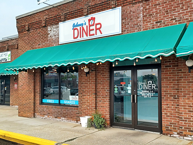 Johnny's Diner welcomes hungry travelers with its classic brick exterior and cheerful green awning &ndash; a beacon of breakfast hope on Hudson's main drag.