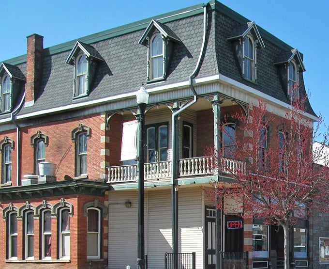 The historic brick building housing John's Wildwood Pizzeria stands as a testament to Edinboro's architectural charm, its vibrant signage promising delicious treasures within.
