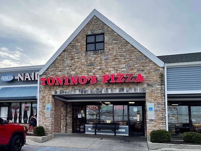 The stone facade and bright red signage of Tonino's Pizza stands as a beacon of hope for the hungry in Harrisburg's retail landscape.