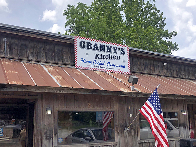 The weathered wooden exterior and iconic red-checkered sign of Granny's Kitchen stand as a promise of authentic home cooking that's kept Arkansans coming back for generations.
