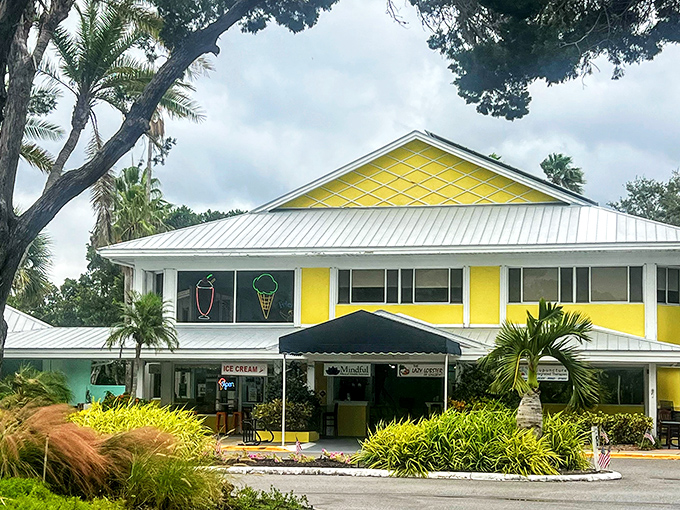 The sunshine-yellow exterior of Lazy Lobster stands out like a cheerful beacon on Longboat Key, promising seafood treasures within its tropical paradise setting.