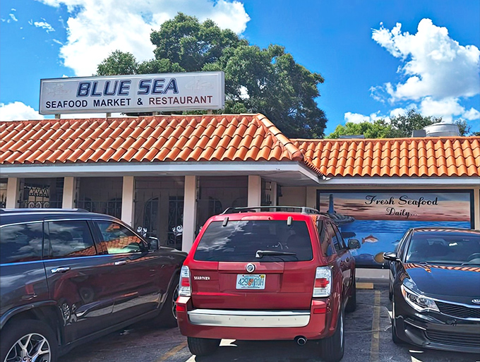 The unassuming exterior of Blue Sea Seafood Market & Restaurant, where that distinctive orange-tiled roof signals seafood salvation awaits beneath.
