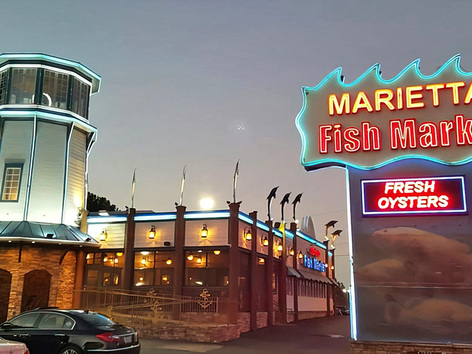 The iconic lighthouse tower and neon sign glow at dusk, beckoning seafood lovers like a coastal mirage in suburban Marietta.