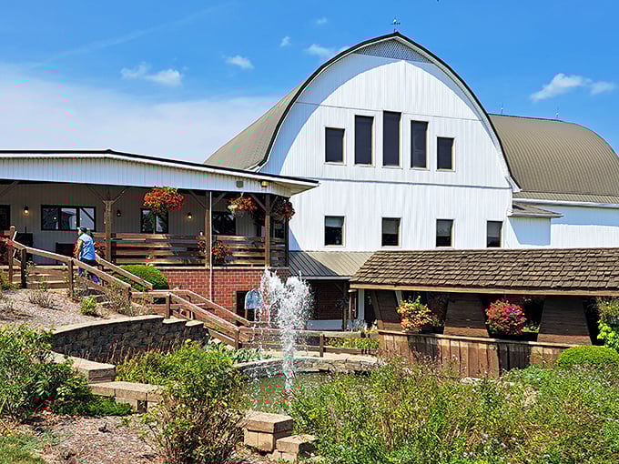 The iconic white exterior of The Barn Restaurant in Smithville welcomes hungry visitors with its distinctive curved roof and charming fountain.