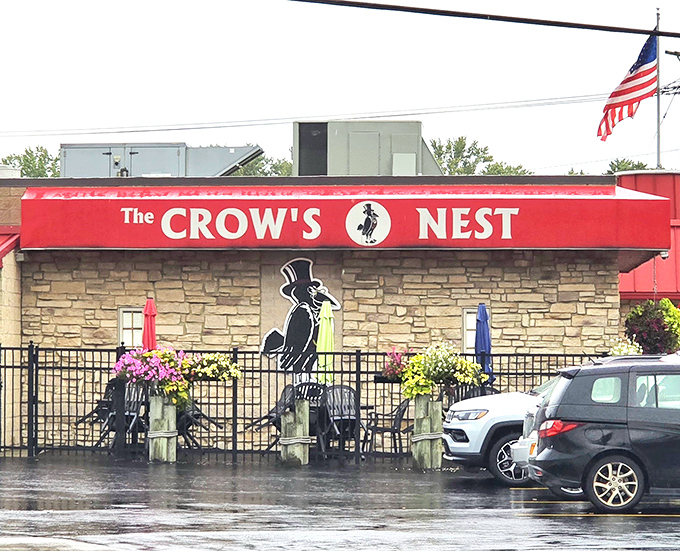 The Crow's Nest stands proud with its bold red awning, promising comfort food treasures within its unassuming walls.