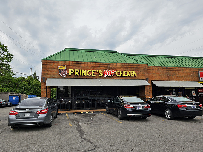 The brick fortress of flavor announces itself with a glowing crown logo, standing proud against the Nashville sky like a beacon for heat-seekers.