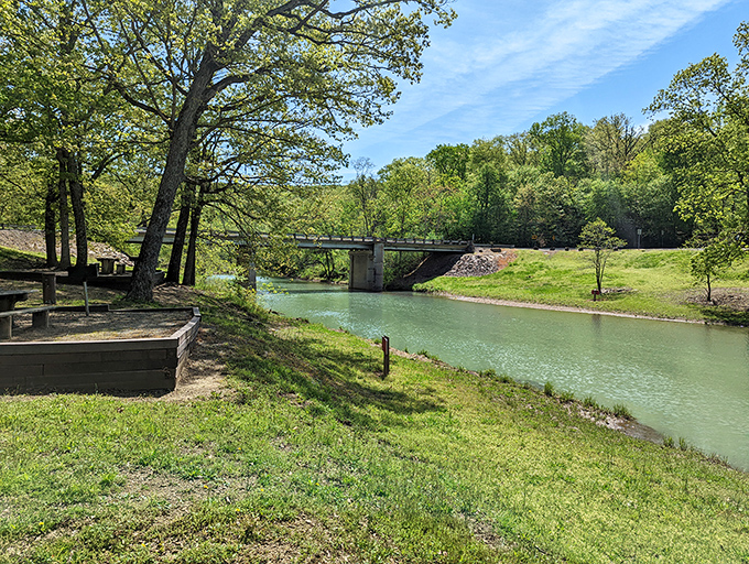 Mother Nature's mirror game at its finest—crystal waters reflect towering trees while a wooden dock beckons adventure seekers at Devil's Den.