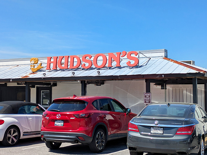 The iconic red Hudson's sign welcomes hungry seafood pilgrims like a maritime lighthouse guiding ships to safe harbor.