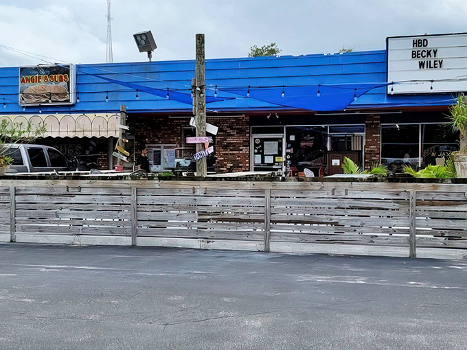The iconic blue exterior with weathered wooden fence tells you everything: this isn't your chain sandwich experience—it's a Jacksonville Beach institution where flavor trumps formality.
