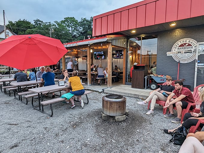 The outdoor patio at Off the Rails beckons like a barbecue oasis, complete with fire pit, red umbrellas, and the promise of smoky delights ahead.