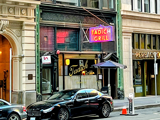 The iconic neon sign of Tadich Grill glows like a beacon for seafood lovers on California Street, a timeless landmark in San Francisco's Financial District.