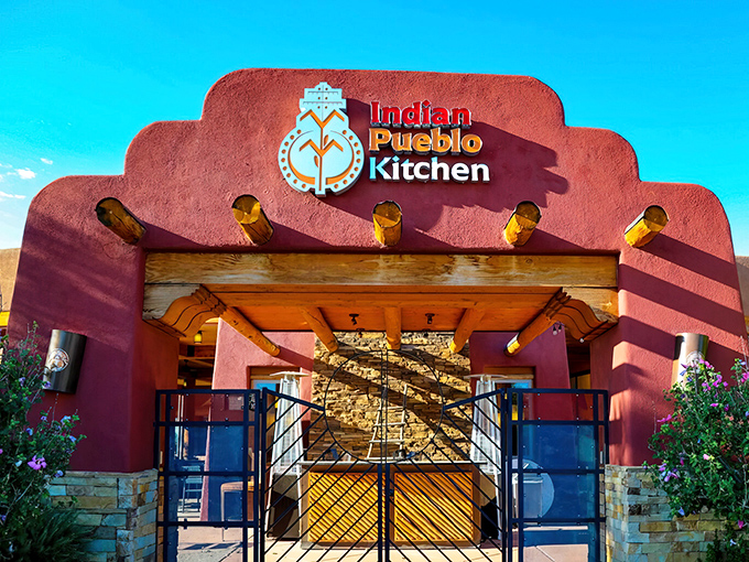 The terracotta-hued entrance to Indian Pueblo Kitchen stands like a culinary portal to centuries of tradition, its vigas reaching out in welcome beneath the New Mexico sky.