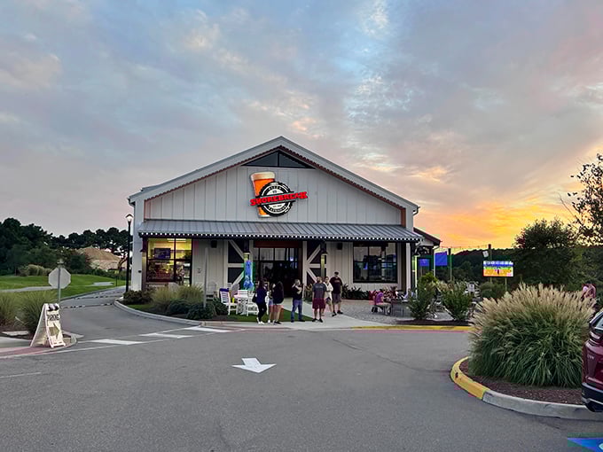 Sunset magic at Shorebreak Pizza & Taphouse, where the Pungo countryside meets coastal cuisine. The white farmhouse exterior promises comfort before you even step inside.