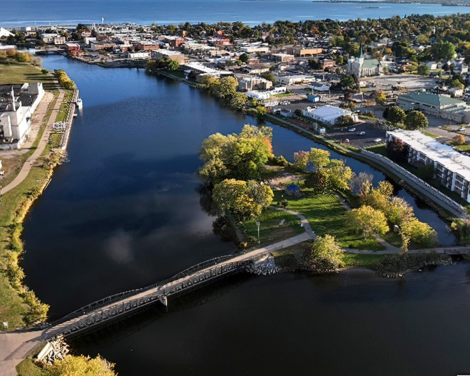 The Thunder Bay River winds through Alpena like a blue ribbon, with Island Park connected by a wooden footbridge straight from a storybook.
