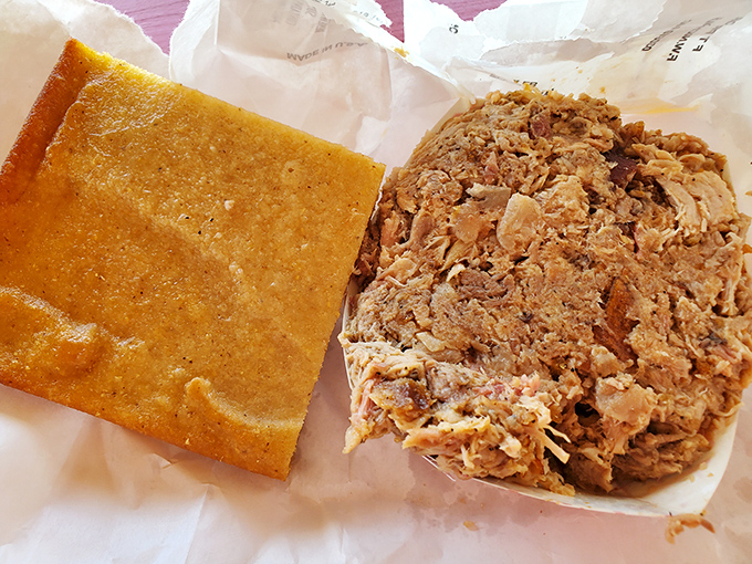 The dynamic duo of Eastern Carolina BBQ: golden cornbread and perfectly chopped pork on butcher paper. No plates needed when the food speaks this loudly.