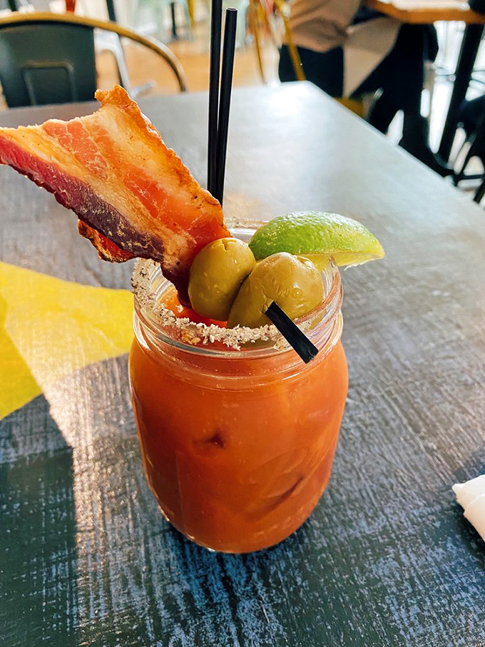 A Bloody Mary that's practically a meal, complete with bacon that stands at attention like it's guarding the olives.