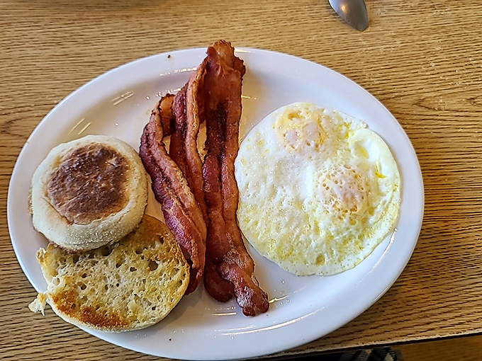 The holy trinity of breakfast: perfectly cooked egg, crispy bacon, and a toasted English muffin. Simple perfection that needs no explanation.