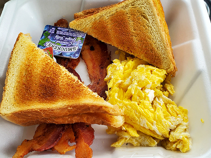 Breakfast perfection on a foam plate. Golden toast, perfectly scrambled eggs, and bacon that's achieved that magical balance between crisp and chewy.
