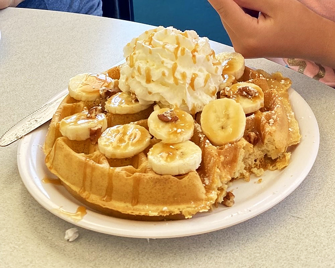 A waffle that doesn't know whether it's breakfast or dessert, topped with bananas, whipped cream, and enough joy to fuel your entire day.