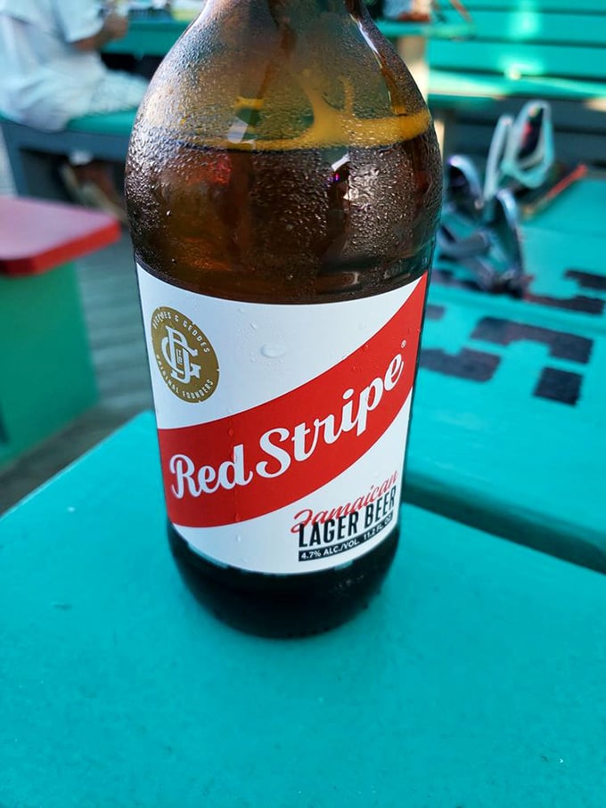 A cold Red Stripe against a turquoise table&mdash;sometimes the simplest pleasures are the most profound, especially after a day in the Florida sun.