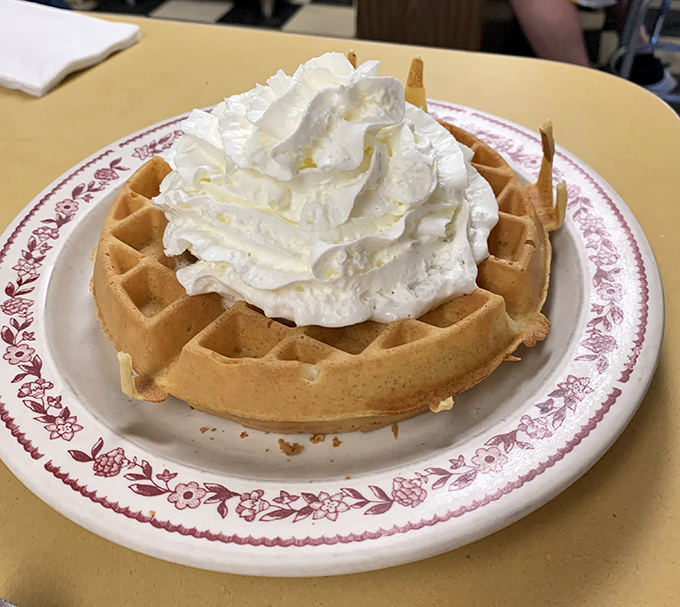 The Belgian waffle, topped with a cloud of whipped cream, sits regally on its vintage plate &ndash; breakfast royalty waiting for its maple syrup coronation.