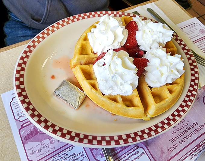 A Belgian waffle topped with fresh strawberries and whipped cream&mdash;breakfast that thinks it's dessert, and we're not complaining.