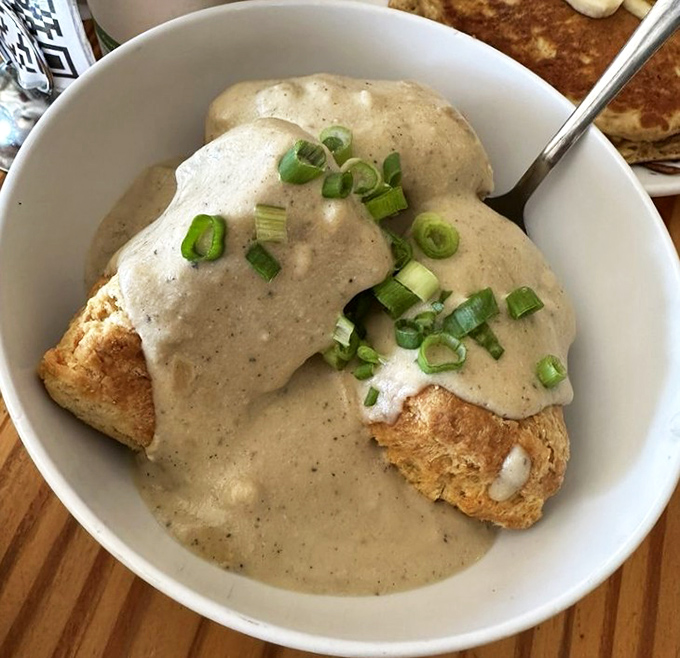 Biscuits swimming in savory gravy that would make a Southern grandmother question everything she knows about breakfast. Those green onions add the perfect pop!