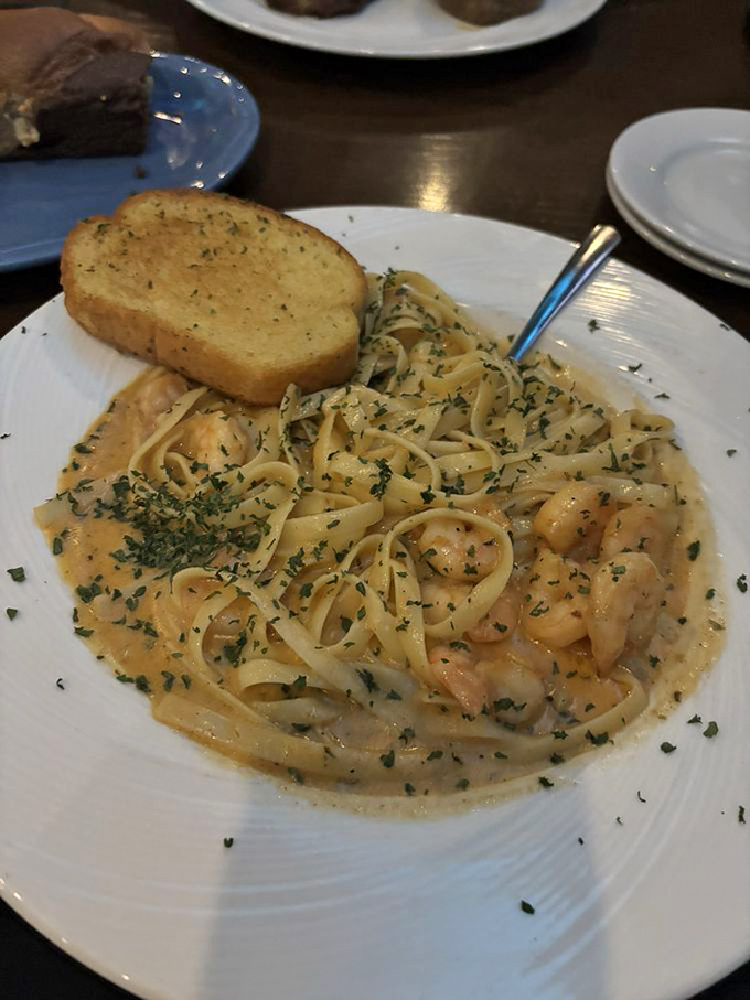 Blackened shrimp swimming in creamy Alfredo sauce with garlic bread&mdash;Italian comfort meets Southern spice in perfect harmony.