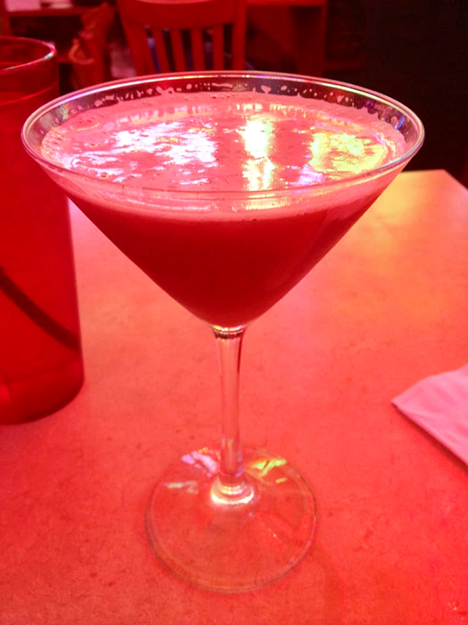 This crimson cocktail isn't just a drink&mdash;it's a sunset in a glass, catching the red glow of neon signs in its shimmering surface.