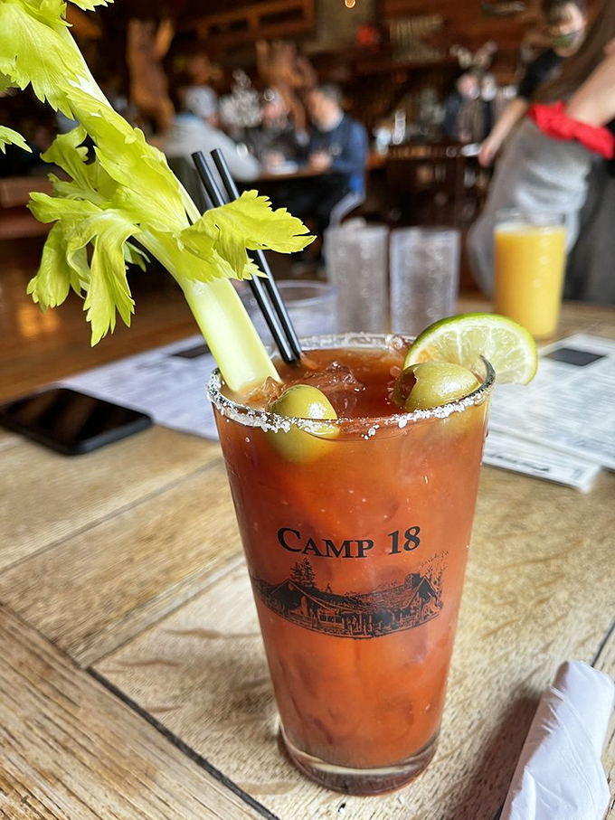 A Bloody Mary with attitude &ndash; garnished with celery, olives, and lime in a souvenir glass that screams "Yes, I'm on vacation, even if it's just for lunch."