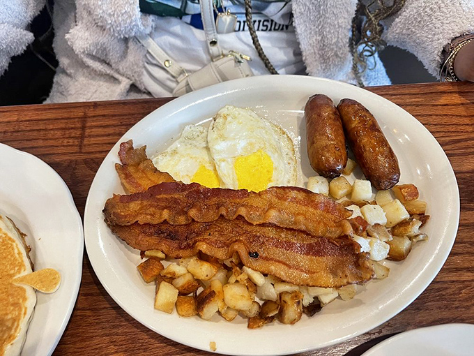 The breakfast that launched a thousand productive mornings: crispy bacon, perfectly fried eggs, and home fries worth setting your alarm for.