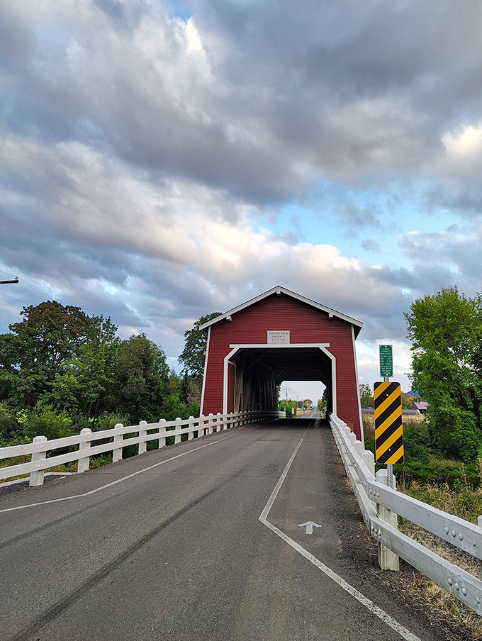 Dramatic clouds create a cinematic backdrop for the bridge's bold red exterior. Even Oregon's famously moody skies can't overshadow this architectural star.