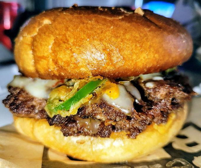 This isn't just a burger—it's architecture with cheese. The green pepper adds that perfect splash of color like a tasteful throw pillow on a meaty sofa.