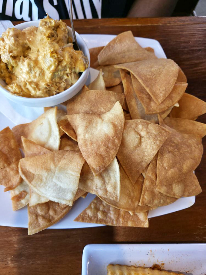 Homemade tortilla chips with a dip that's clearly been designed by someone who understands the importance of proper chip-to-dip ratios.