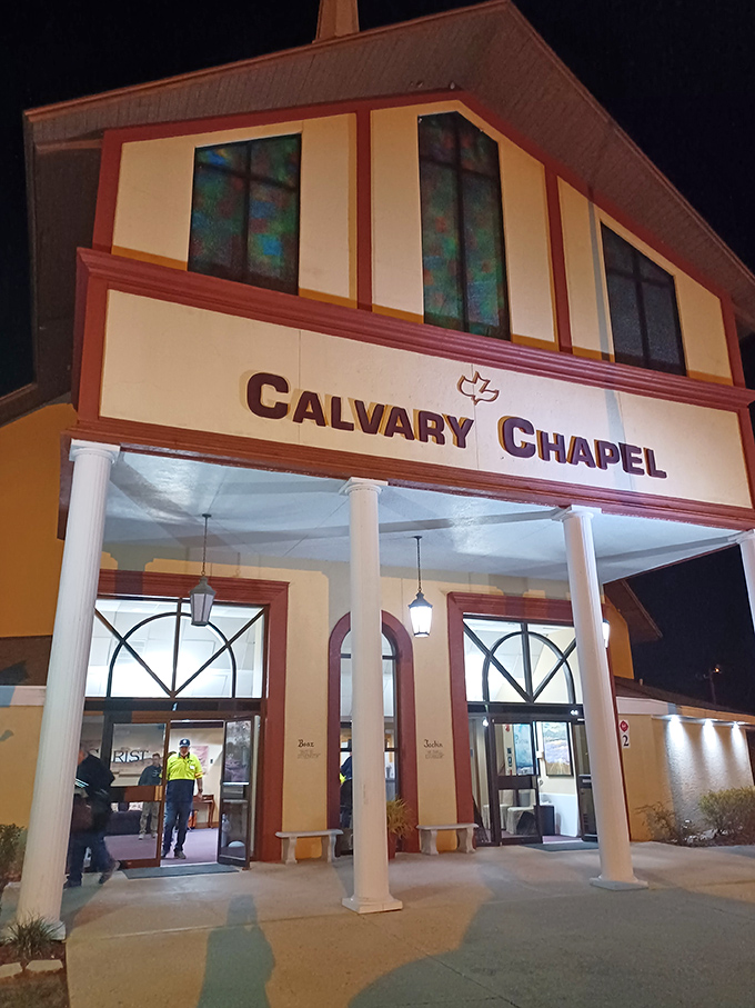 Calvary Chapel welcomes evening worshippers with warm light spilling through stained glass &ndash; spiritual comfort with architectural flair.