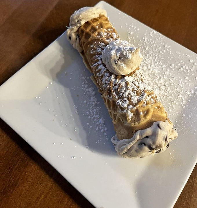 A cannoli that would make any Sicilian grandmother nod in approval &ndash; crisp shell, creamy filling, and just the right dusting of powdered sugar.
