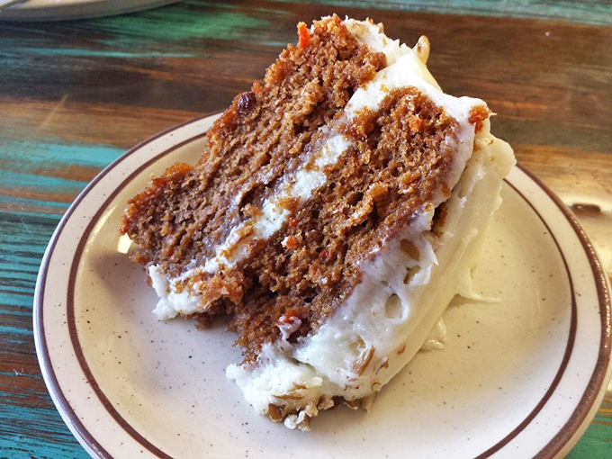 Carrot cake towering with cream cheese frosting so generous it qualifies as architectural ambition meeting delicious reality for dessert.
