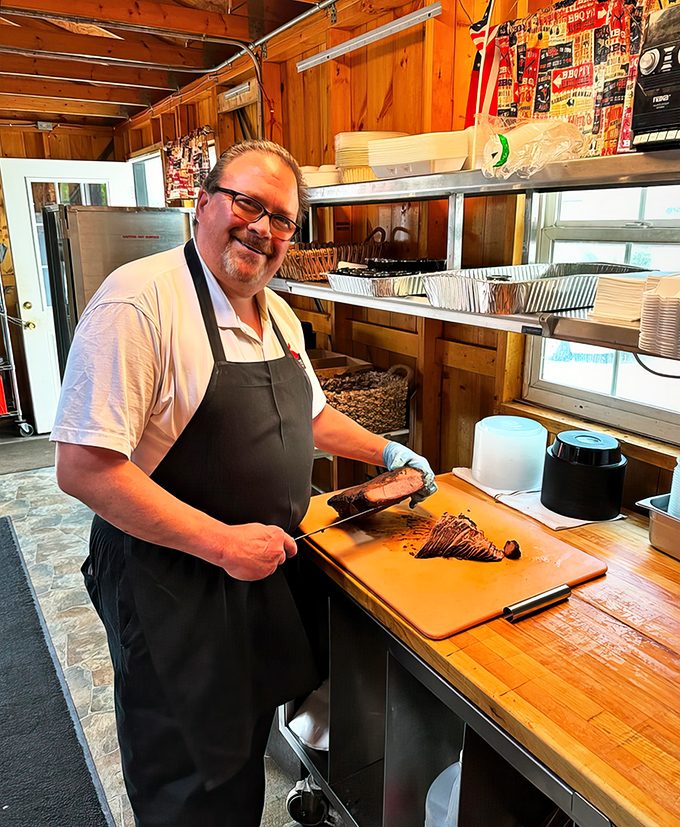 A pitmaster in his element, knife in hand, creating brisket magic. This is the face of someone who knows meat better than most know their passwords.