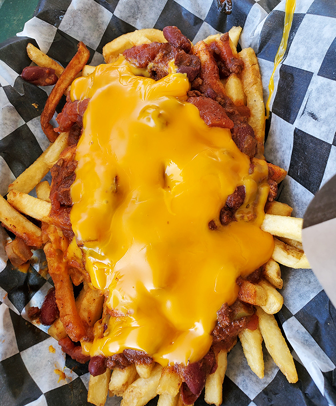 Chili cheese fries piled high with enough toppings to require both hands, a napkin strategy, and absolutely zero regrets whatsoever.