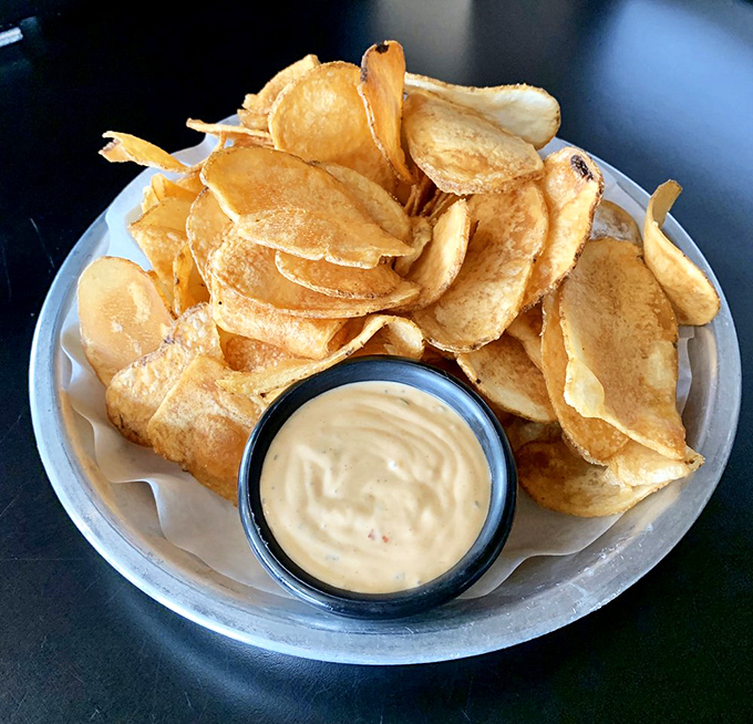 House-made chips that shatter with satisfying crispness, paired with a dip that doesn't come from any plastic tub. This is snacking with integrity.