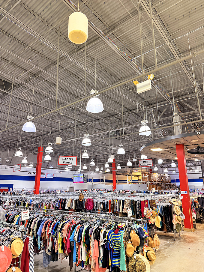 The clothing section stretches toward the industrial ceiling, organized by type and size&mdash;a rainbow of fashion possibilities at fraction-of-retail prices.