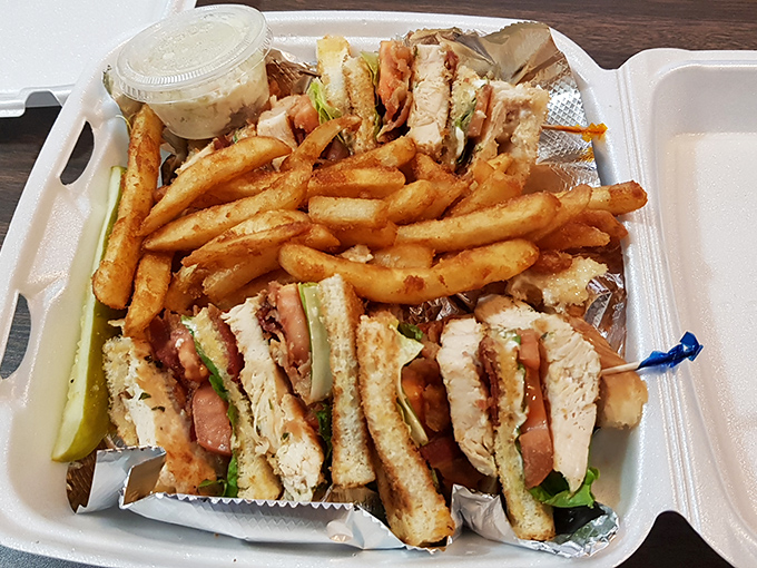 The club sandwich&mdash;that architectural marvel of toast, meat, and vegetables&mdash;served with a mountain of fries that demands to be shared.