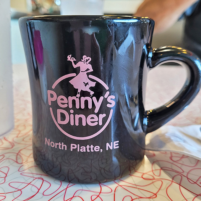 The iconic black Penny's Diner mug&mdash;a collector's item that makes coffee taste better through some mysterious diner alchemy.