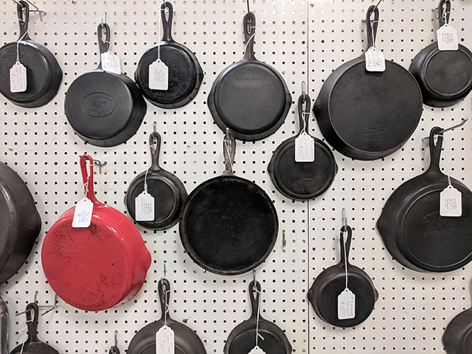 Cast iron cookware hanging like dark medals of culinary honor. That lone red pan is the rebel of the bunch&mdash;the Keith Richards of kitchen equipment.