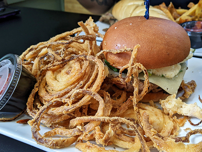 A burger so perfectly constructed it deserves its own architectural award, with those onion rings providing structural support for maximum flavor delivery.