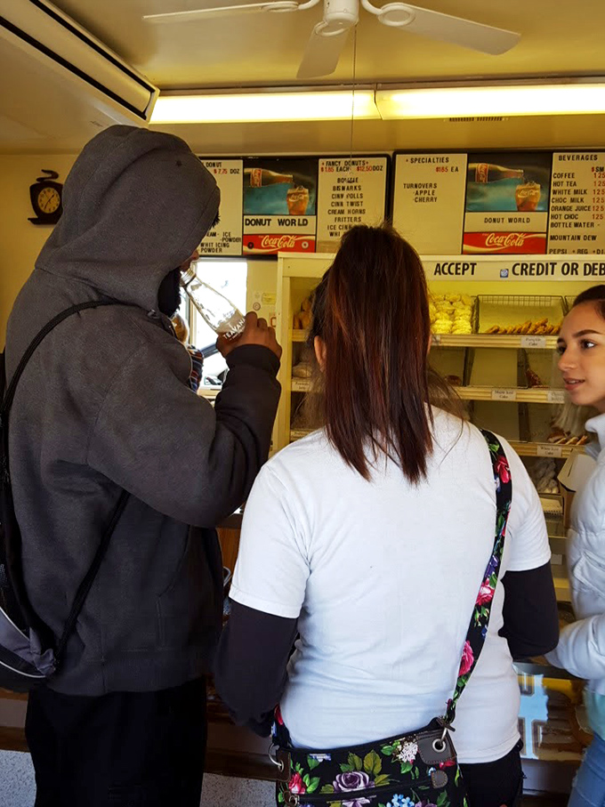 The universal language of donuts brings customers together at the counter, where important decisions about glazed versus chocolate are made daily.