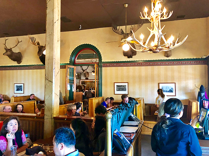 Wooden booths filled with happy diners under the watchful gaze of mounted deer. The antler chandelier casts the kind of glow that makes everyone look like they're in love.