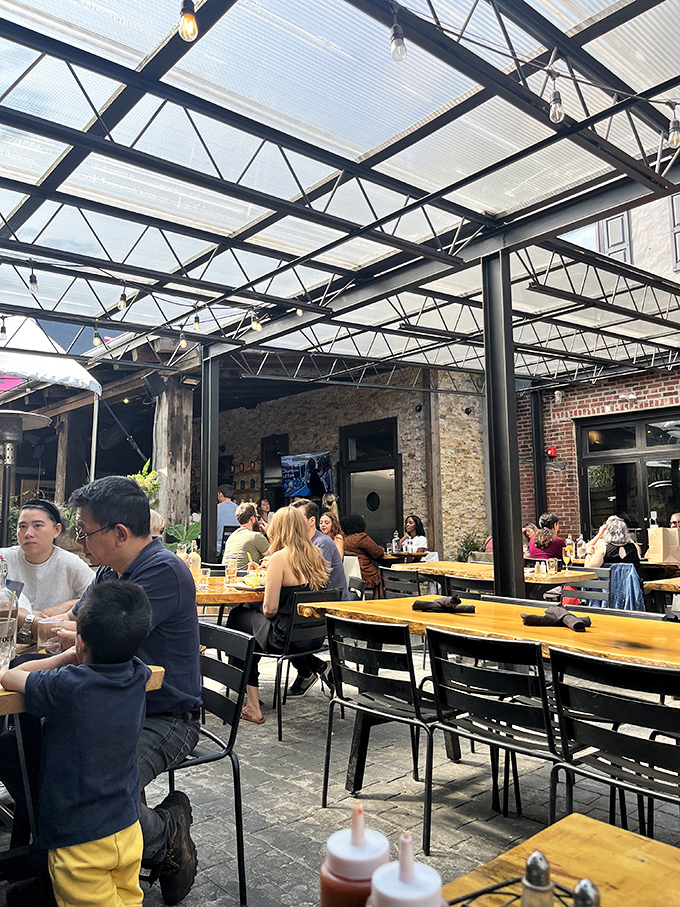 Under the industrial-chic canopy, strangers become neighbors over shared tables and the universal language of "that looks amazing."