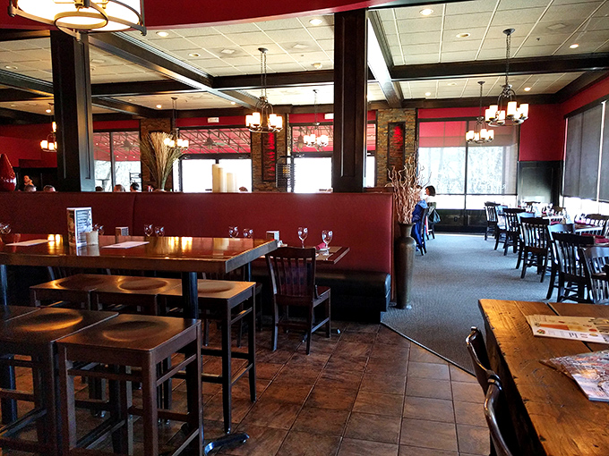 Red walls frame wooden tables where memories are made between bites, proving that the best dining rooms feel like extensions of home, only with better lighting.