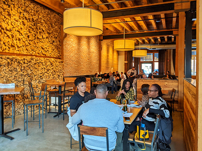 Rustic wooden dividers create intimate dining pockets within the vast space, like having your own private dining room without missing the energy.